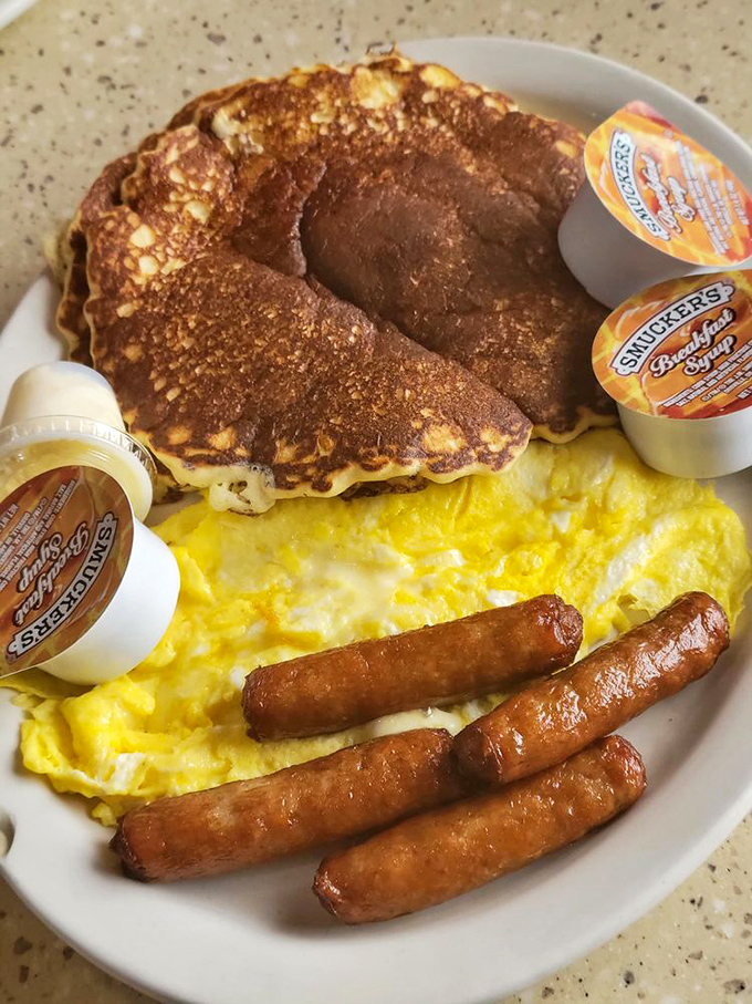 The breakfast trinity: perfectly cooked pancakes, scrambled eggs, and sausage links&mdash;a holy alliance on a single plate.