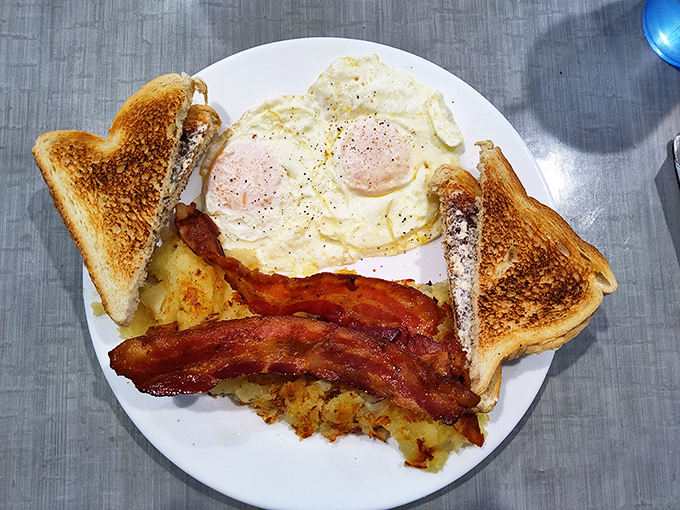 A breakfast plate that understands the assignment &ndash; perfectly cooked eggs, crispy bacon, and those famous home fries.