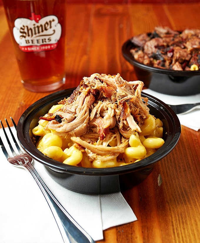 Mac and cheese acting as a velvet throne for perfectly smoked pulled chicken. Comfort food that's dressed for a night out.
