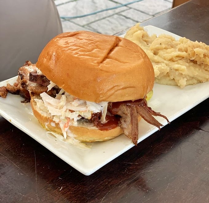 The pulled pork sandwich that launched a thousand road trips, served with creamy mashed potatoes that would make your grandmother nod in approval.