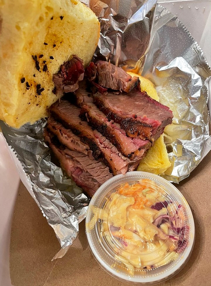 Slices of brisket with that telltale smoke ring, cornbread that doesn't apologize for being cornbread, and slaw that cuts through the richness.