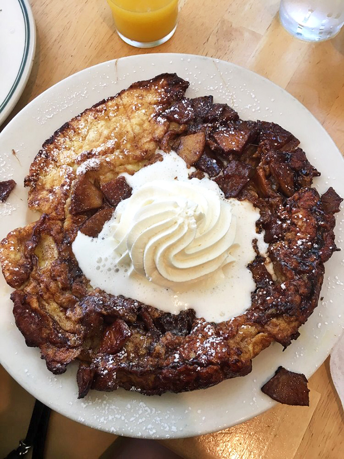 The German Pancake arrives like breakfast theater—a crater of deliciousness topped with whipped cream and waiting for its lemon squeeze.