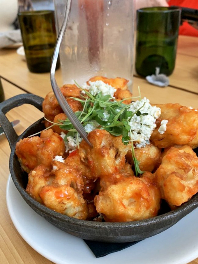 Cauliflower "wings" that might just convert the most dedicated carnivore&mdash;crispy, saucy, and topped with fresh herbs and cheese that whisper, "Who needs chicken?"