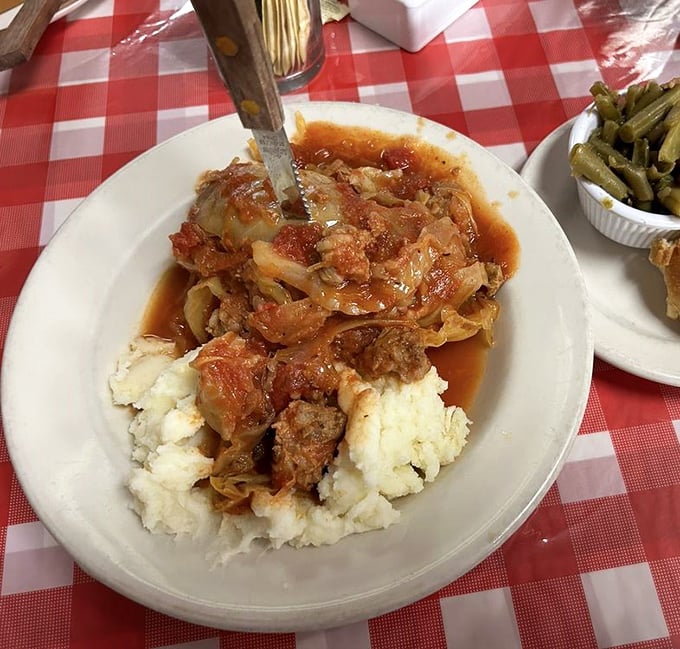 Cabbage rolls swimming in tomato sauce atop cloud-like mashed potatoes—proof that M & M knows lunch deserves the same loving attention as their famous breakfasts.