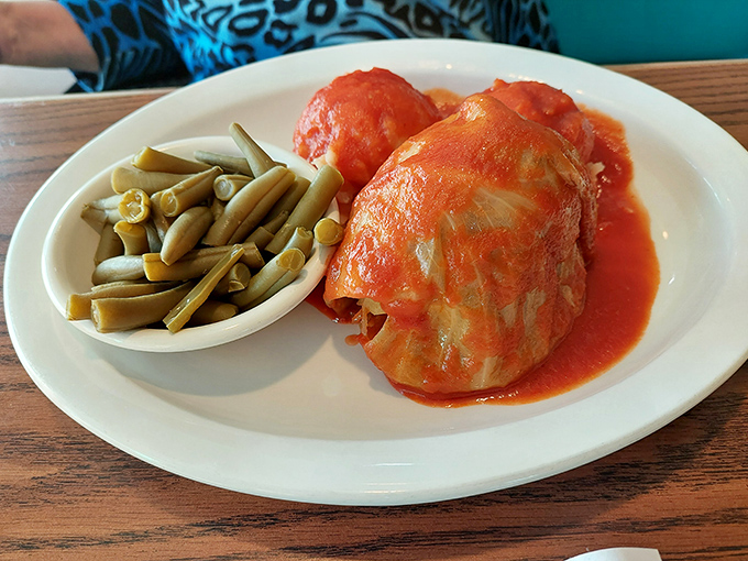 Cabbage rolls swimming in tomato sauce like little edible presents, each one wrapped with more care than most holiday gifts.