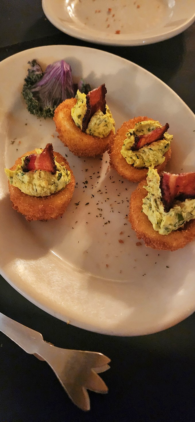 These aren't just onion rings&mdash;they're edible pedestals showcasing what appears to be a creamy filling and bacon, proving that appetizers can have ambition too.