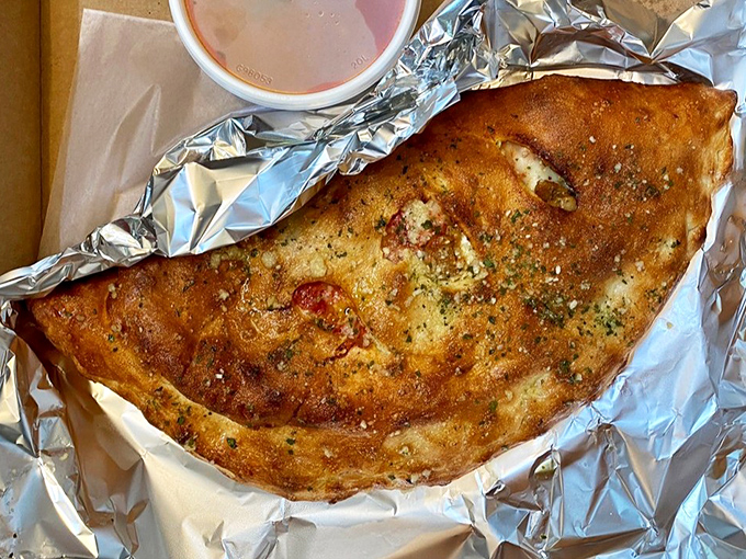 This isn't just a calzone&mdash;it's a golden-brown treasure chest filled with savory delights and served with marinara for extra dipping pleasure.