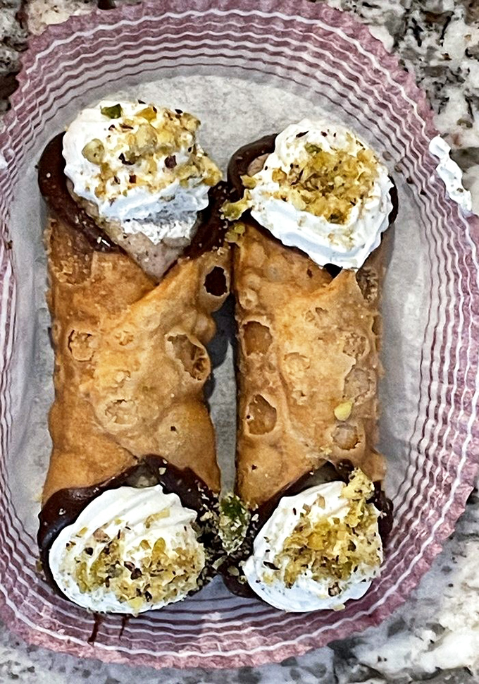These cannolis aren't just dessert; they're edible treasure chests filled with sweetened ricotta gold and topped with a sprinkle of pistachio jewels.