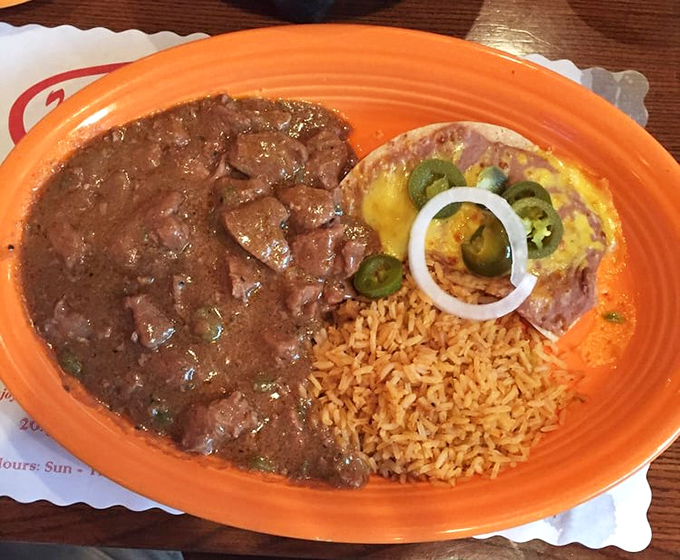 Carne Guisada that would make your abuela proud &ndash; tender beef swimming in rich gravy alongside Spanish rice and a cheese-topped tostada.
