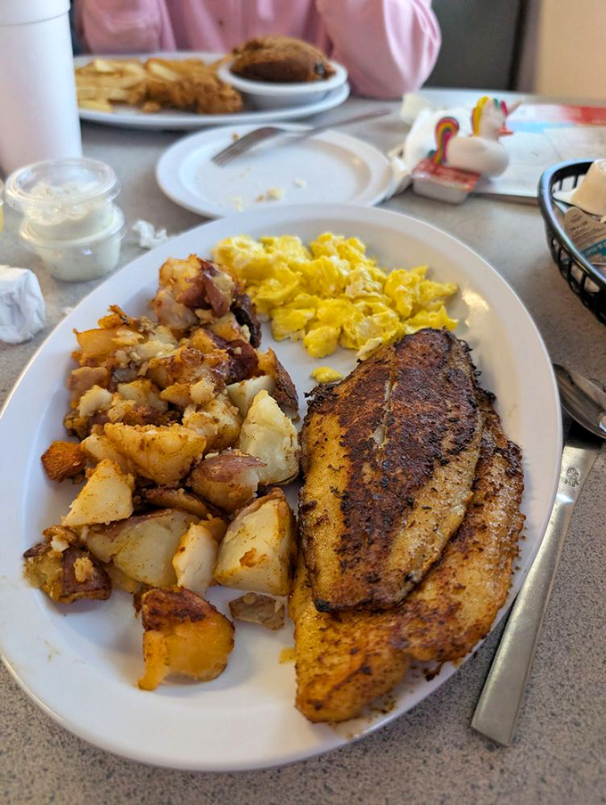 A breakfast trifecta that hits all the right notes: golden potatoes, fluffy scrambled eggs, and fish that would make any angler proud.