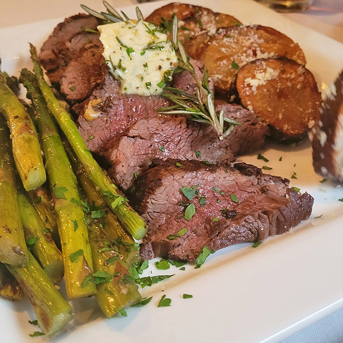 Perfectly pink slices of beef with charred asparagus and roasted potatoes. The kind of plate that makes conversation stop mid-sentence.
