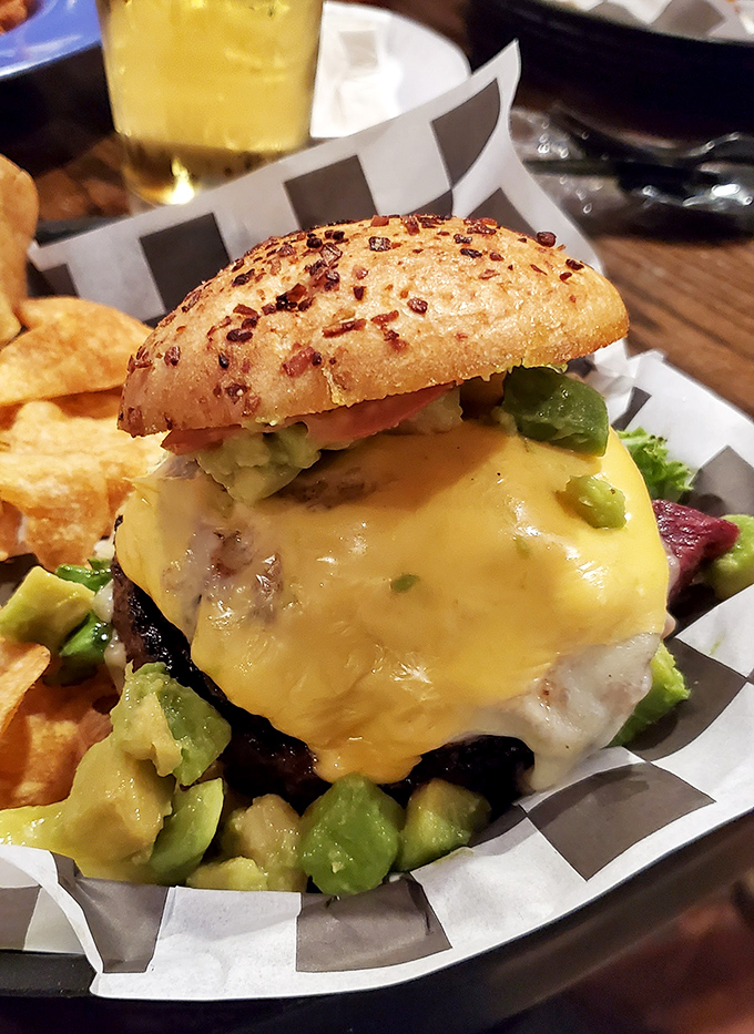 This isn't just a burger—it's a skyscraper of beef, cheese, and avocado that requires architectural planning before the first bite.
