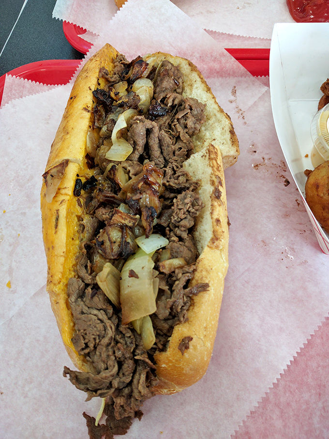 The cheesesteak in its natural habitat &ndash; overflowing with perfectly grilled meat and onions. A sandwich that demands both hands and your full attention.