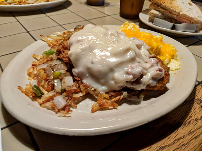 The chicken fried steak arrives smothered in peppery gravy with a side of hash browns that could convert a carb-avoider in one crispy bite.