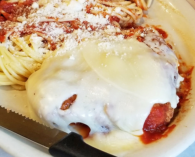 Chicken Parmesan that would make any Italian grandmother nod in approval &ndash; a melty cheese blanket covering seasoned perfection.