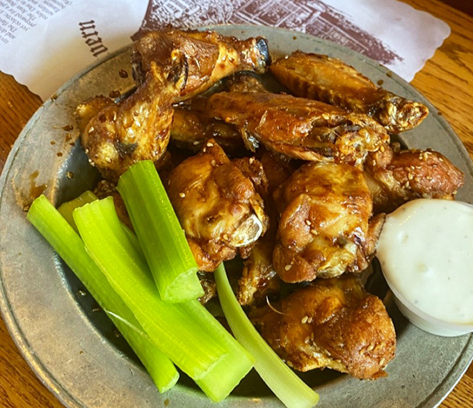 Wings so perfectly glazed they'd make the tavern's ghost residents materialize just for one more bite, served with the crisp celery stalks of satisfaction.