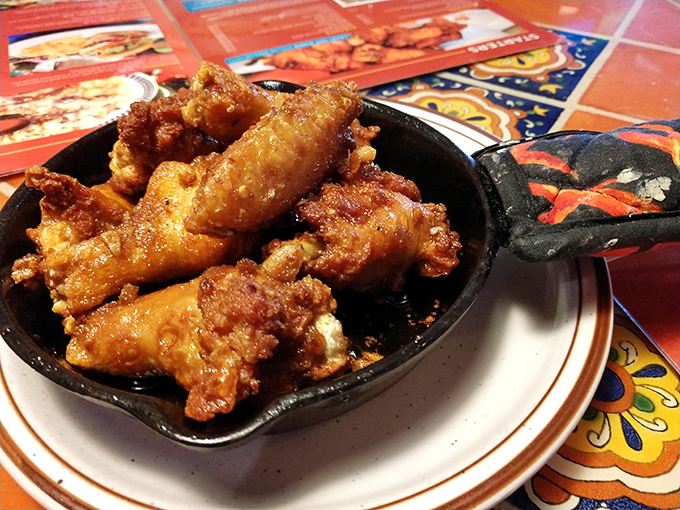 These aren't just wings – they're crispy, golden-brown tickets to flavor town, served in a traditional skillet that keeps them hot until the last bite.