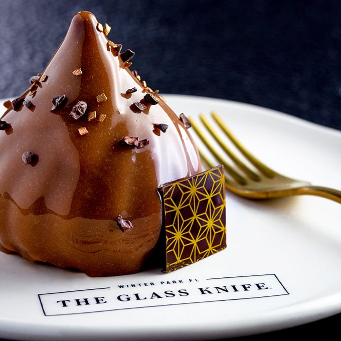 The Chocolate Onyx dessert isn't just served; it's presented like the crown jewels of Winter Park, complete with a geometric chocolate garnish that's too pretty to eat. Almost.