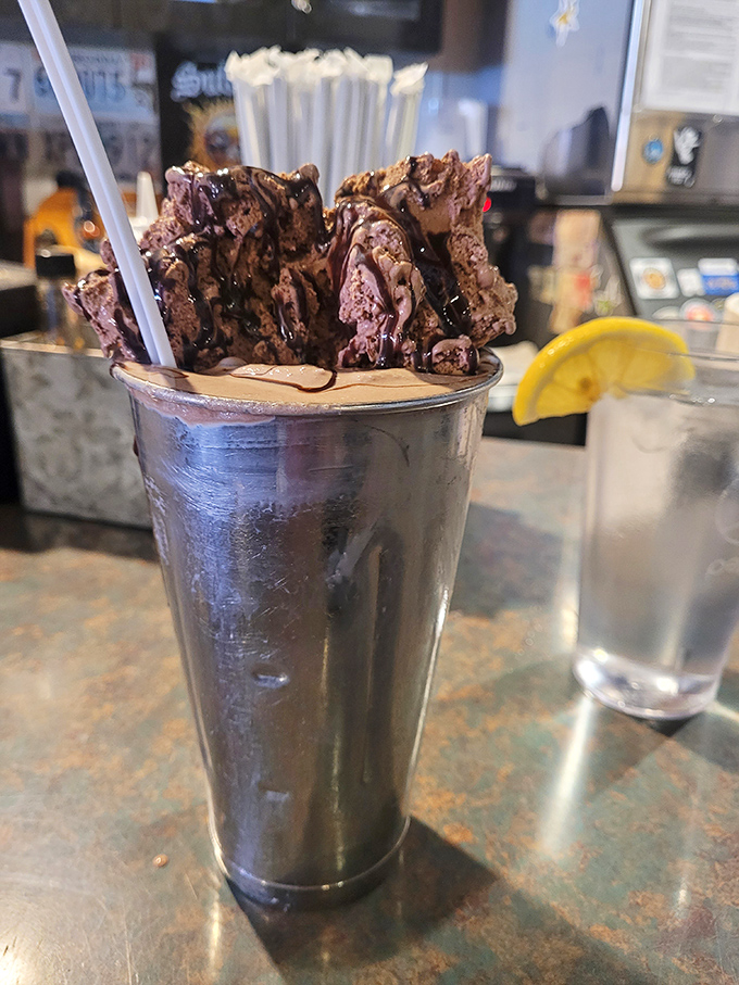 This chocolate shake isn't just a drink—it's a structural engineering marvel topped with what appears to be enough chocolate to qualify as dinner.