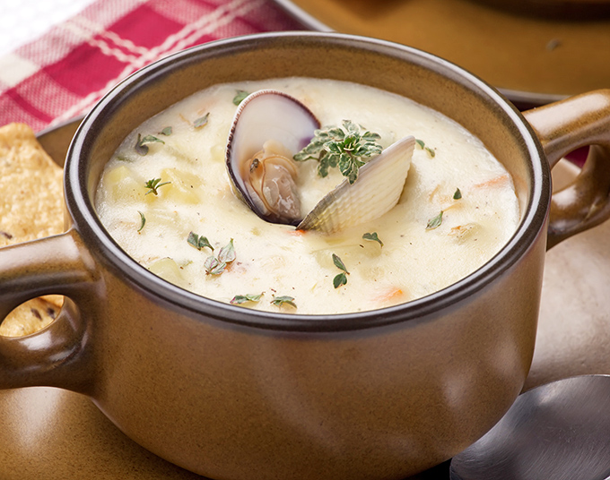 A steaming mug of clam chowder that strikes the perfect balance between creamy and brothy. Comfort in a cup.v