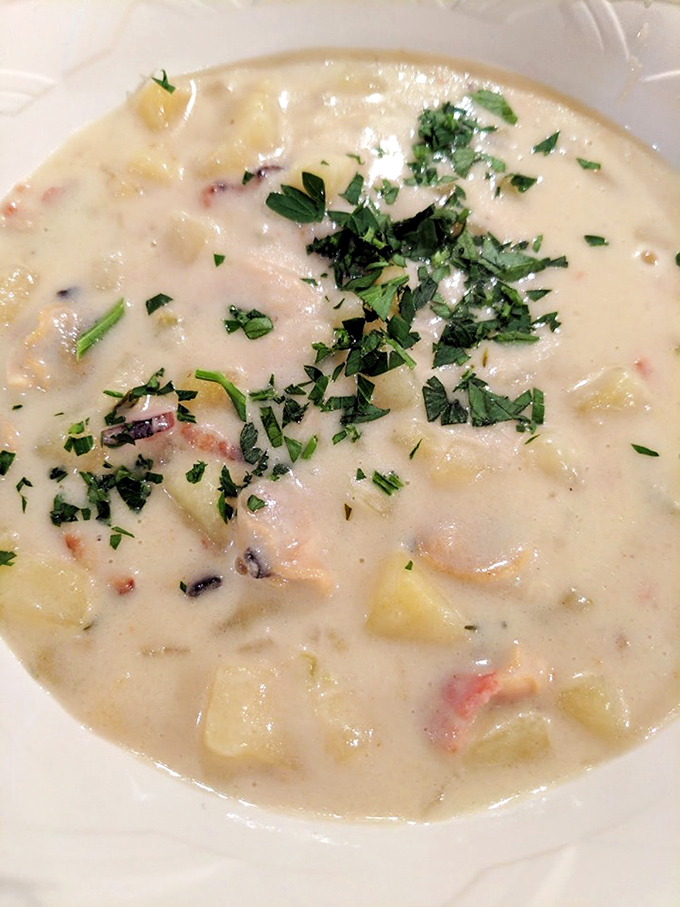 Creamy clam chowder topped with fresh herbs - comfort in a bowl that warms every corner.