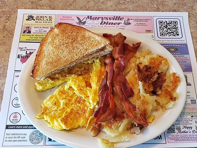 The breakfast trinity: golden toast, fluffy scrambled eggs, and bacon cooked to that perfect point between chewy and crisp.
