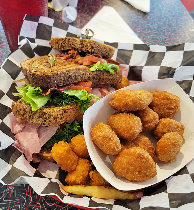 A sandwich built like a three-story architectural marvel, with hush puppies standing guard. Comfort food that hugs you back.