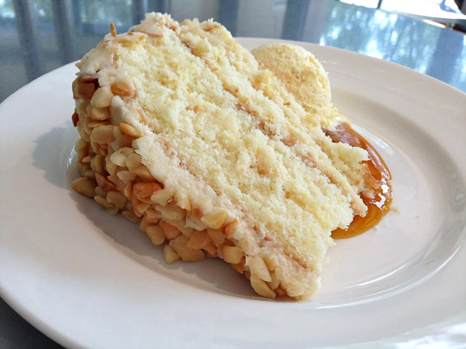 Layer upon layer of vanilla cake with macadamia nuts standing guard around the perimeter. This isn't dessert; it's architecture you can eat.