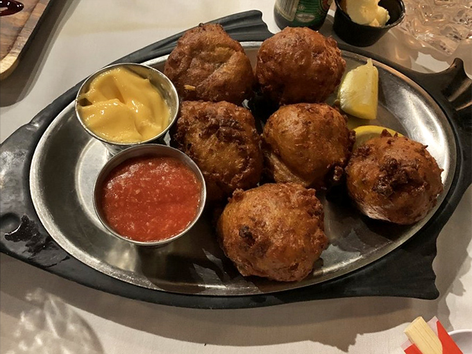 Golden-fried conch fritters: crunchy on the outside, tender within, and utterly irresistible. Two dipping sauces because sometimes life's too short to choose just one.