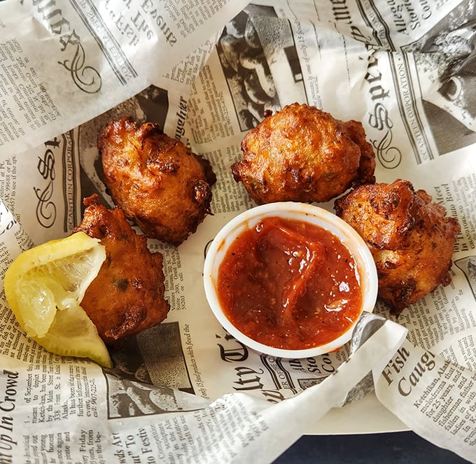 Conch fritters that could make a Bahamian homesick, served on newspaper because some traditions are too delicious to modernize.