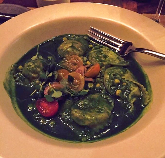 Ravioli swimming in a vibrant green sea of culinary brilliance. Each pillowy pocket is like getting a delicious little love letter from an Italian grandmother you never knew you had.