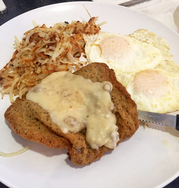 Country fried steak smothered in creamy gravy alongside crispy hash browns and eggs&mdash;the breakfast that says "go back to bed" and "conquer the world" simultaneously.