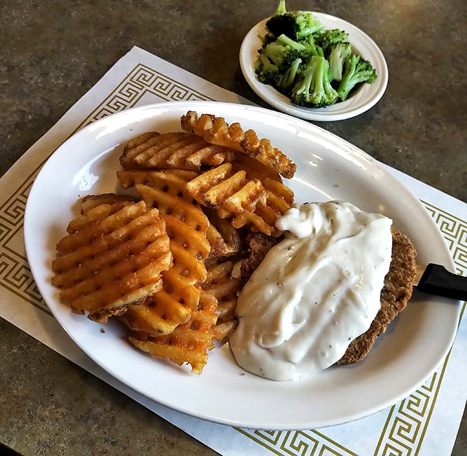 Country fried steak smothered in gravy that would make your grandmother simultaneously proud and jealous. Those waffle fries aren't just a side dish, they're a religion.