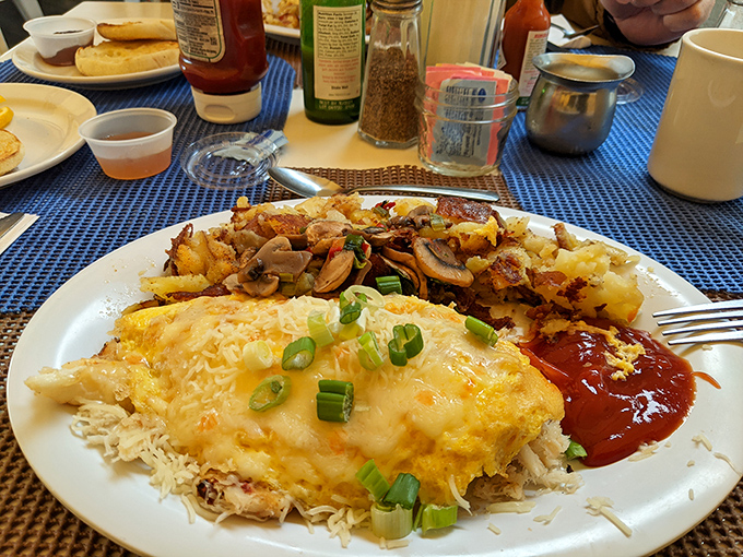 Dig into a hearty breakfast featuring a cheesy crab omelet, crispy hash browns, and all the fixings for a satisfying start!