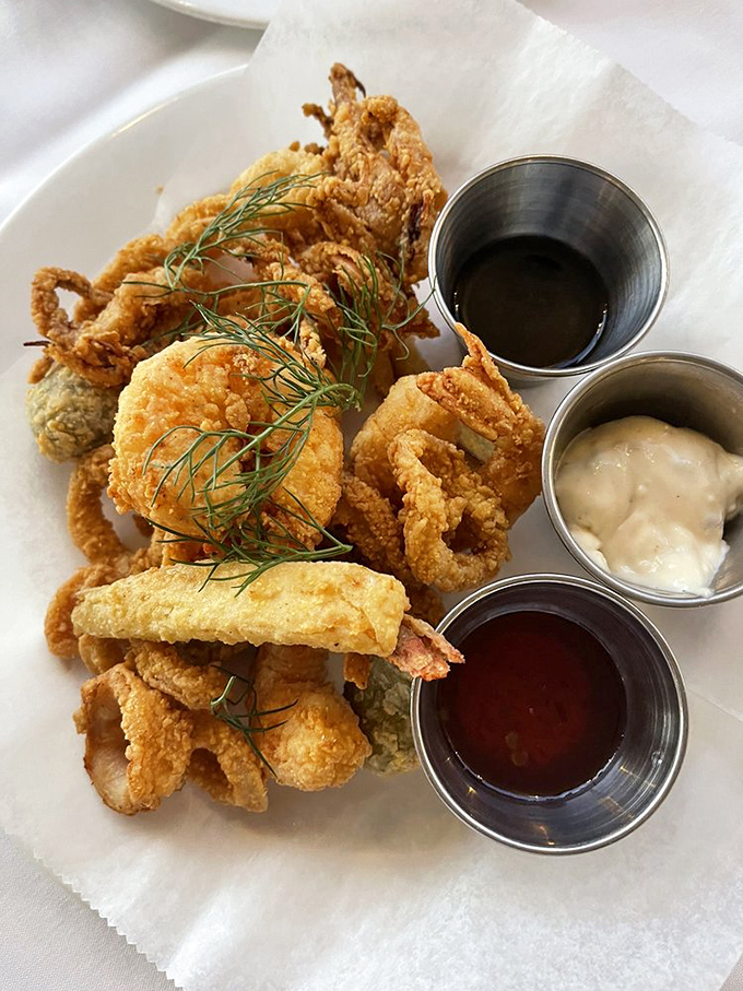 Crispy calamari that shatters like glass between your teeth, with three perfect dipping sauces that make sharing this plate a true test of friendship.