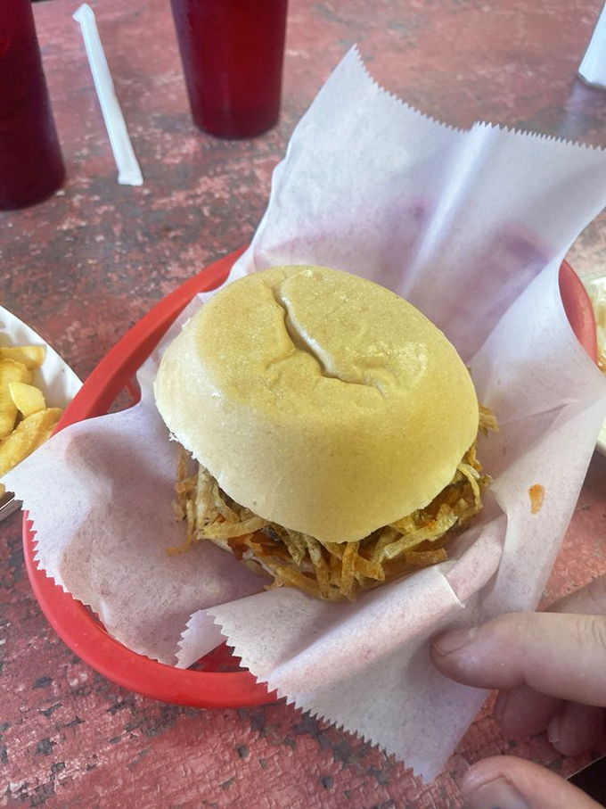 Behold the star attraction: a Cuban burger cradled in a soft roll, crowned with crispy potato strings—proof that perfection can fit in one hand.