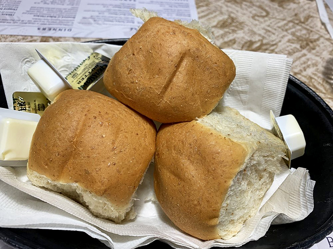 Fresh dinner rolls waiting for their butter destiny. These pillowy wonders make you question why you ever settled for store-bought bread in the first place. 