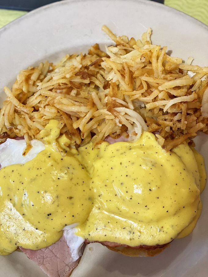 Eggs Benedict with a mountain of hash browns &ndash; because sometimes breakfast should be an adventure, not just a meal.