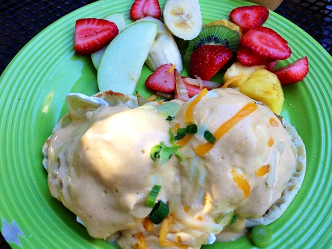 Eggs Benedict reimagined with coastal flair. The fresh fruit side isn't an afterthought&mdash;it's the perfect counterpoint to creamy hollandaise heaven.