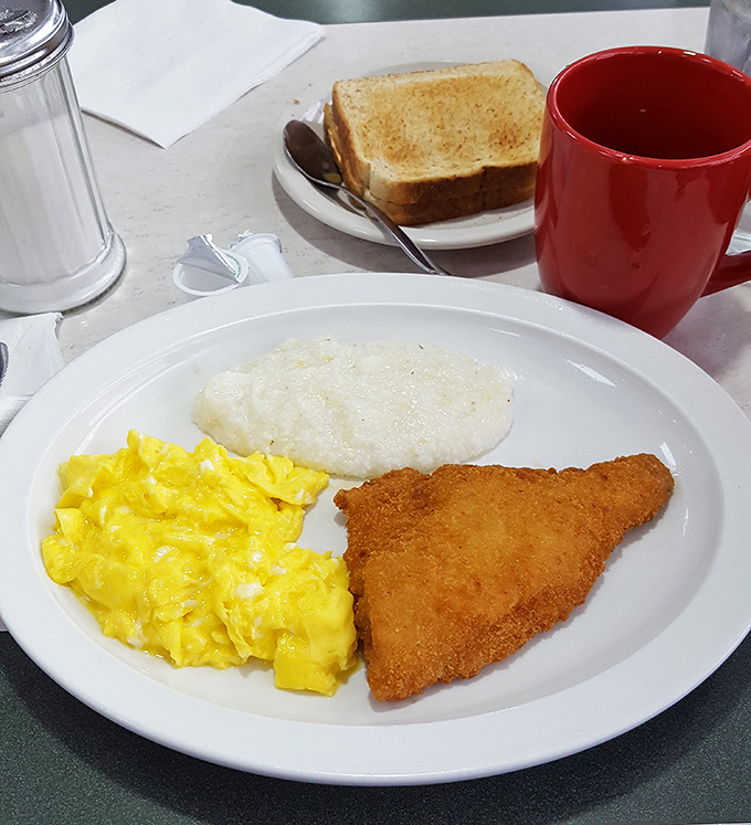 The breakfast trinity: perfectly scrambled eggs, fish with a golden crust, and grits that would make any Southerner nod in approval.