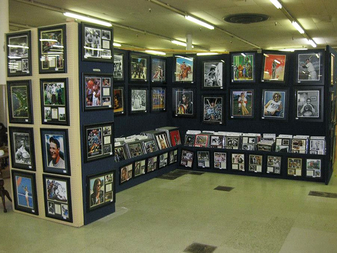 A gallery of framed memories featuring sports legends and cultural icons. Someone's heroes, preserved under glass, waiting for new walls to grace.