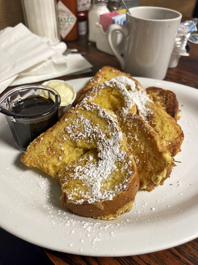 French toast that's achieved the impossible balance: custardy center, crisp edges, and just enough powdered sugar to make you feel like you're getting away with something.