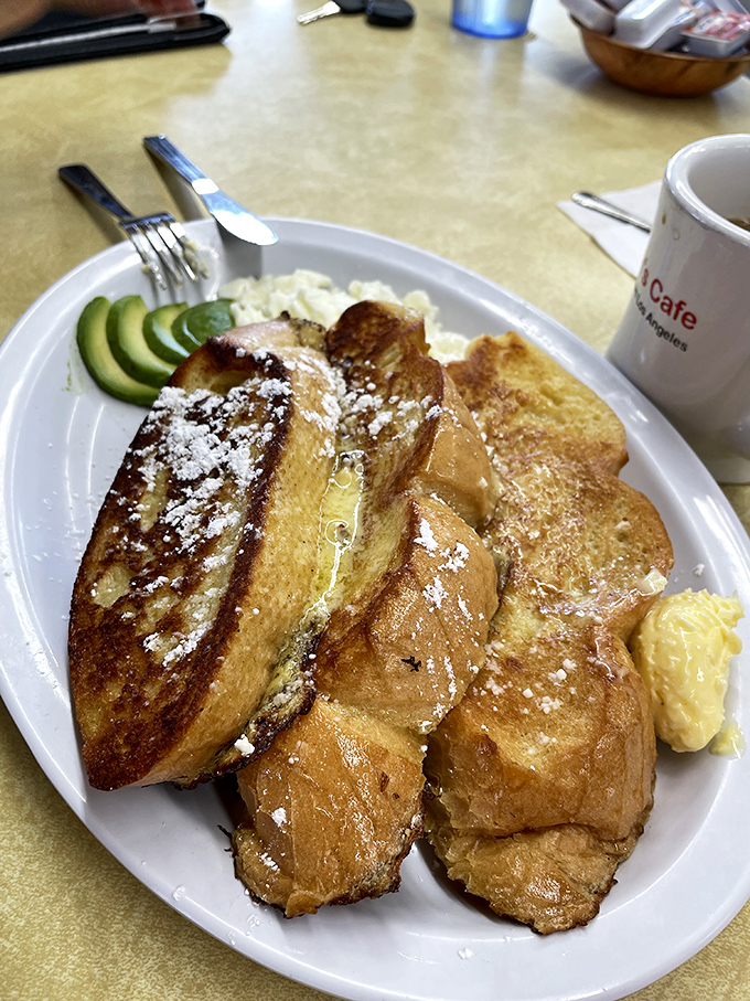 French toast that's achieved the golden ratio: crisp exterior, custardy interior, and enough powdered sugar to make your coffee jealous.