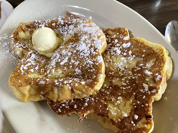 French toast that's achieved celebrity status &ndash; golden, butter-kissed, and dusted with powdered sugar like fresh snow on a perfect winter morning.