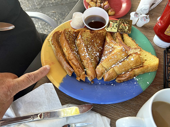 French toast so perfectly golden it belongs in Fort Knox. The powdered sugar snowfall makes even Florida feel like it has seasons.