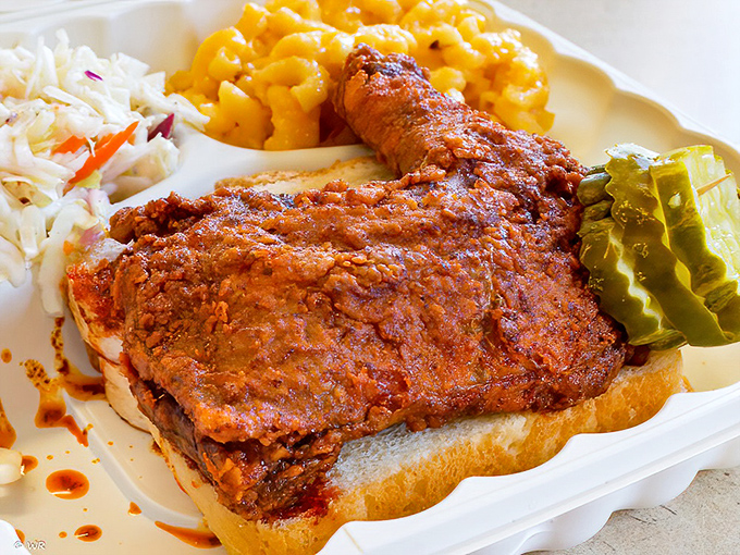 The perfect hot chicken sandwich – crispy, spicy goodness nestled between bread with cooling slaw and pickles standing by for relief.