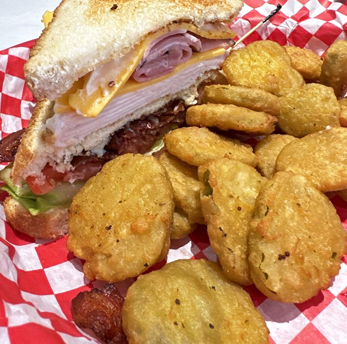 This club sandwich and fried pickles combo proves that sometimes the best things in life come in baskets lined with checkered paper,