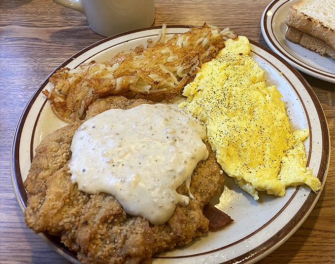 Country fried steak with eggs and hash browns&mdash;the breakfast trinity that's converted more morning skeptics than Sunday sermons. This plate doesn't just feed you&mdash;it sustains you.