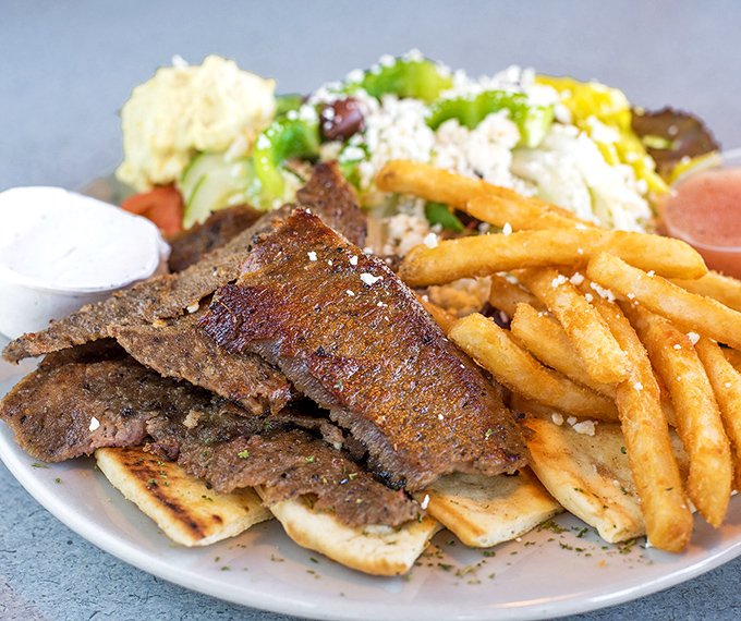 Perfectly seasoned gyro meat resting on pita with a side of golden fries &ndash; proof that lunch at breakfast places is never an afterthought. 