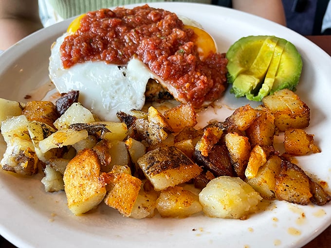 A breakfast burrito smothered in salsa with sliced avocado and those famous Cajun home fries&mdash;morning fuel that means business.